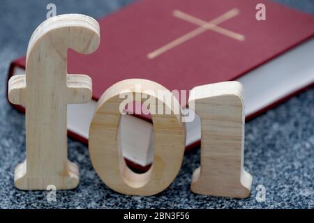 Wooden letters forming the word Foi ( Faith ) and Bible. Christian ...