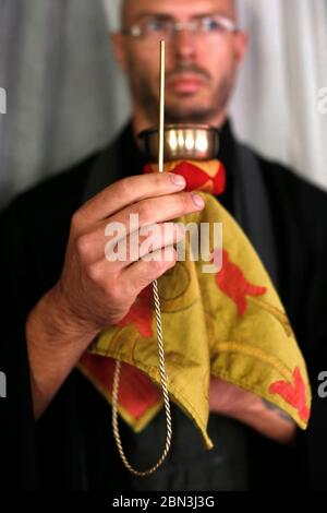 Zen monk sounding a hand-bell called inkin during a buddhist ceremony ...