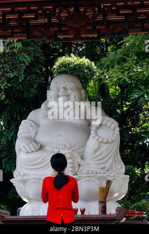 Phat Quang Buddhist temple. Woman worshipper kneeling in prayer and ...
