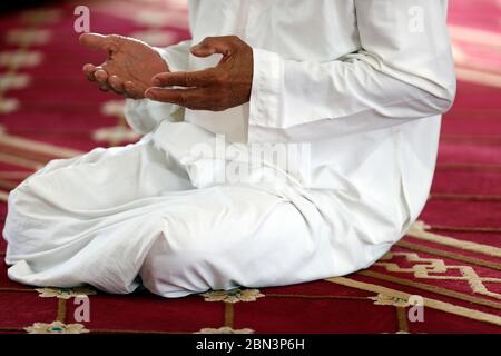 Masjid Ar-Rohmah mosque. Muslim man praying with islamic prayer beads ...