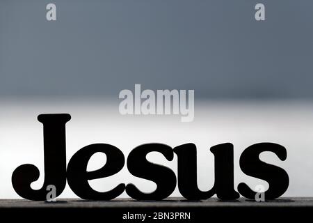 Wooden letters forming the word JESUS with heart on a background of ...