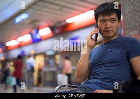 Guy talking on smartphone at train station Stock Photo - Alamy