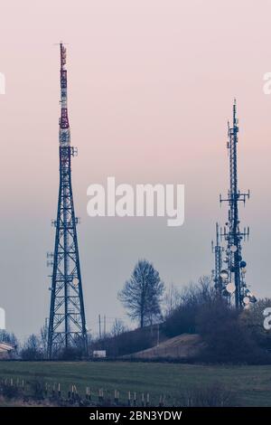 Telecommunications tower with cellular antennas and repeaters against a clear blue sky with two ...