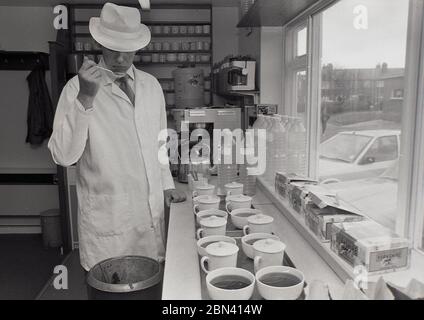 1980s, tea tasting session.....a man in a white coat and hat, a trained ...
