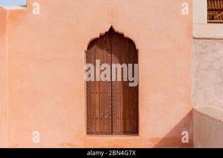 Wooden arabic style arch window portal in stone wall with ornaments ...