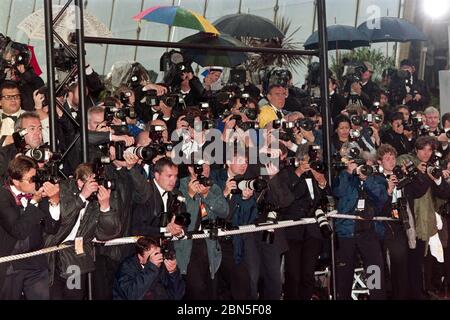 CANNES, FRANCE. May 1997: Photographers shooting a starlet on the beach ...