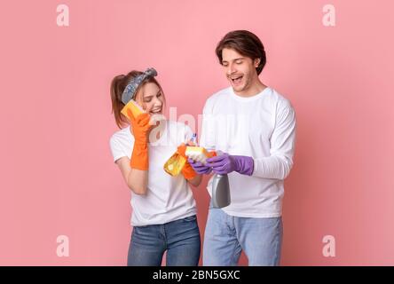 Crazy Cleaning. Joyful couple using sponges like cellphones, having fun ...