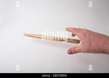 A narrow, handmade spirtle in spalted maple, photographed against a ...