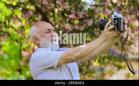 Everyone photogenic. Senior man taking selfie photo vintage camera ...