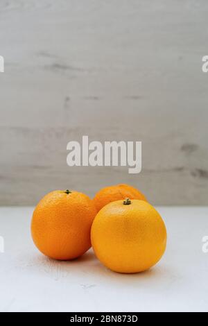 Mandarin Oranges - three mandarin oranges on a rustic wooden board ...