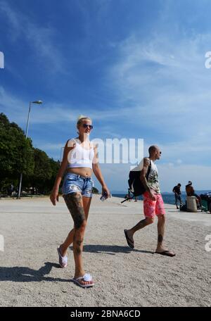 Tourist enjoying the Adriatic sea views from the Nova Riva promenade in ...