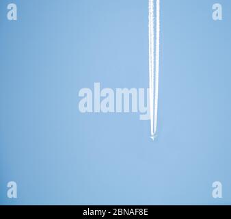 A passenger jet airplane leaves a contrail, or vapor trail, in its wake ...