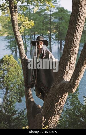 Young woman in poncho standing on shore at beach Stock Photo - Alamy