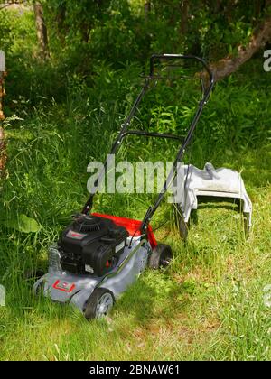 Lawn mower in a garden path Stock Photo - Alamy