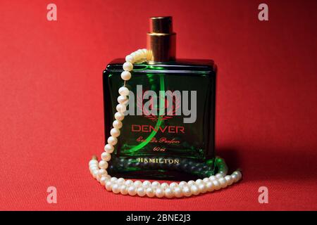 Green color perfume bottle isolated on red background. Denver Hamilton ...