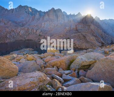 The first rays of sunshine above the Sierra Crest, illuminating granite ...