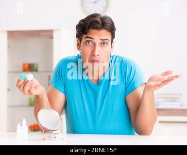 The man trying contact lenses at home Stock Photo - Alamy