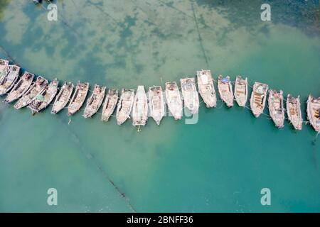 An aerial view of fishing ships either parking at or floating around a ...