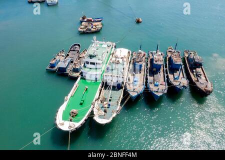 An aerial view of fishing ships either parking at or floating around a ...