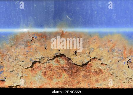 Fragment of an old blue car with a dirty rusted wheel and a scratched ...