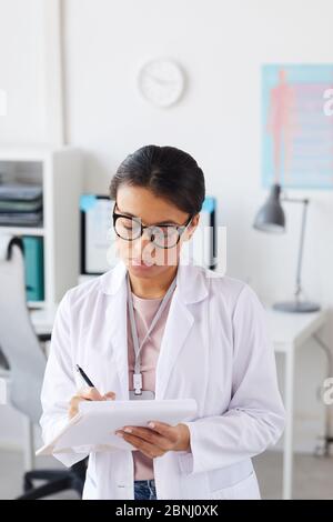 young Asian woman doctor standing with arms crossed in white lab coat ...