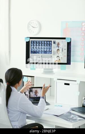Doctor holding mri scan during video chat on laptop in hospital Stock ...