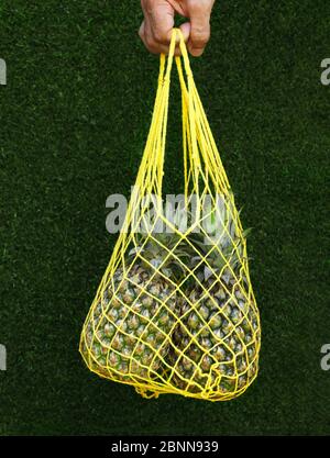 A closeup of pineapple and fruits in a shopping paper bag Stock Photo ...