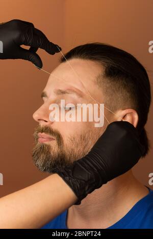 Process of threading procedure in barber shop. Professional barber ...