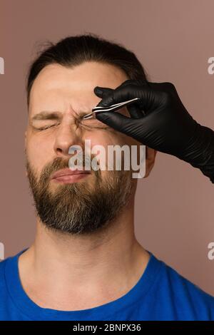 Closeup of process of threading procedure in barber shop. Professional ...
