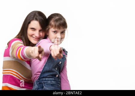 Mom and daughter point a finger at the frame, side empty space in the ...