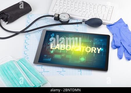 Tablet pc and medical stuff with LABORATORY inscription, prevention ...