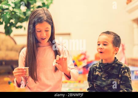Small children playing with fire at home. A child plays with matches in ...