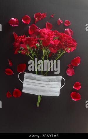 red roses and n95 mask on a black background Stock Photo - Alamy