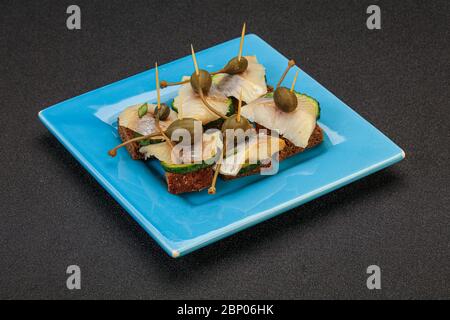 Herring fillet canape snack with caperberry and cucumber Stock Photo ...