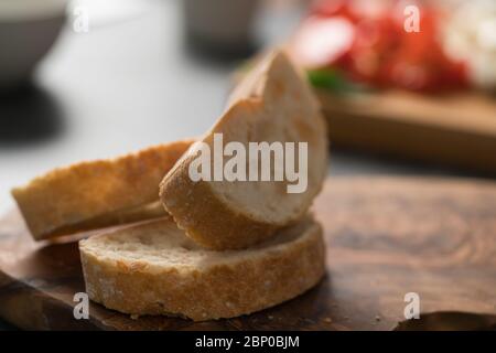 Loaf of ciabatta bread and slices on a cutting board on a wooden table ...