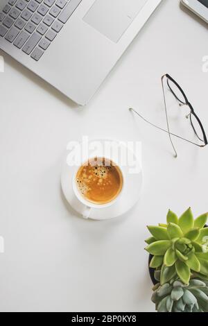 Workplace. Computer, cup of coffee and plant on wooden table, top view ...