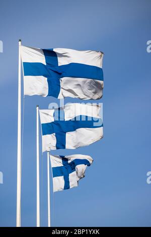 Three finnish national flags on the wind against the blue sky Stock ...