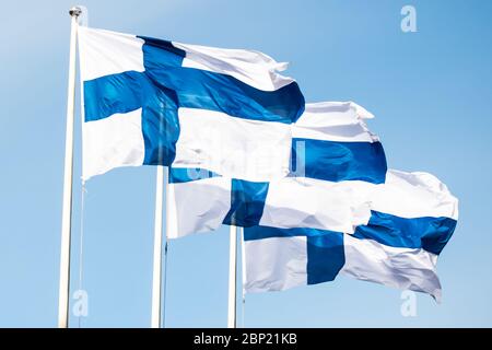 Three finnish national flags on the wind against the blue sky Stock ...
