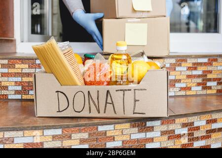 Canned food near boxes with donation lettering on table Stock Photo - Alamy