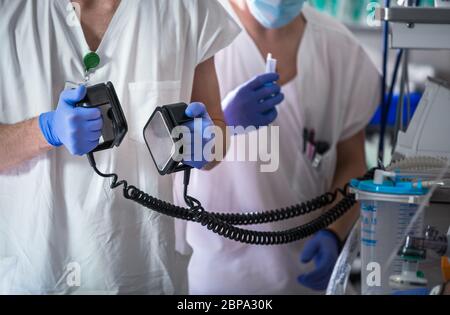 Hand holding defibrillator Stock Photo - Alamy