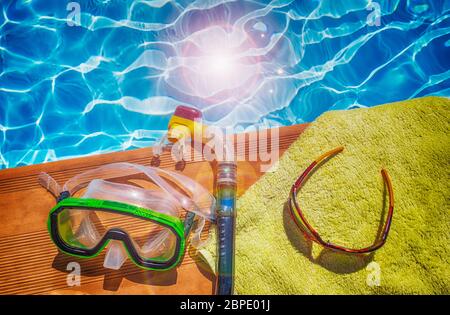 Sun flare in sunlit swimming pool with snorkel mask, sunglasses and ...