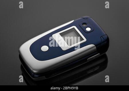 Old battered and scratched mobile phone on a gray background with ...