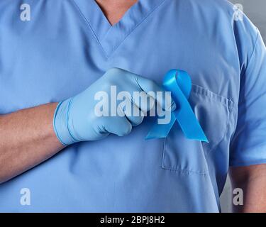 Prostate cancer awareness. Doctor holding light blue ribbon as symbol ...