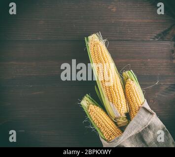 Ripe corn on an old brown wooden table. Yellow corn, top view Stock ...