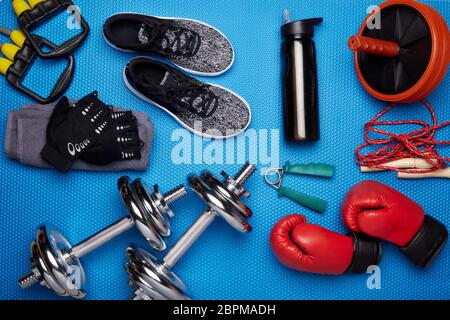 Dumbbells, skipping rope and expander on pink background Stock Photo ...