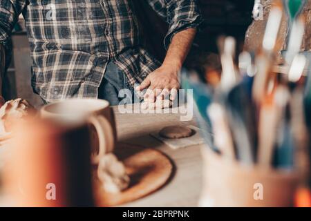 Male potter rolls clay to create a cup Stock Photo - Alamy