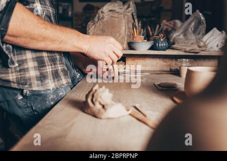 Male potter rolls clay to create a cup Stock Photo - Alamy
