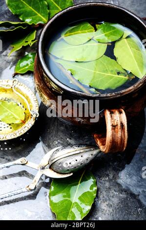 Dry bay leaves in a clay bowl isolated on white. Dried laurel leaf ...