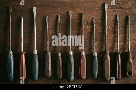 Wooden handles of old vintage screwdrivers propped upright in a wooden ...