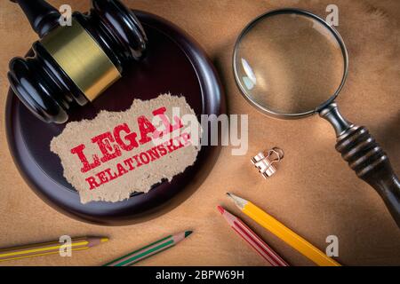 LEGAL RELATIONSHIP concept. Judge's hammer, stationery and magnifying ...